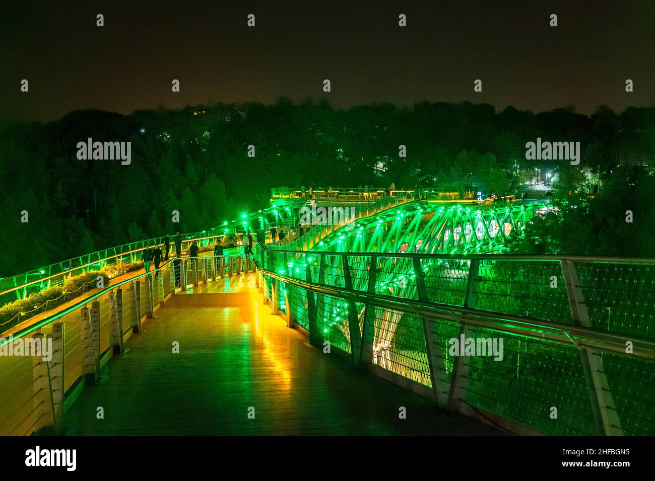 Tourists and locals wandering over the brightly illuminated pedestrian ...