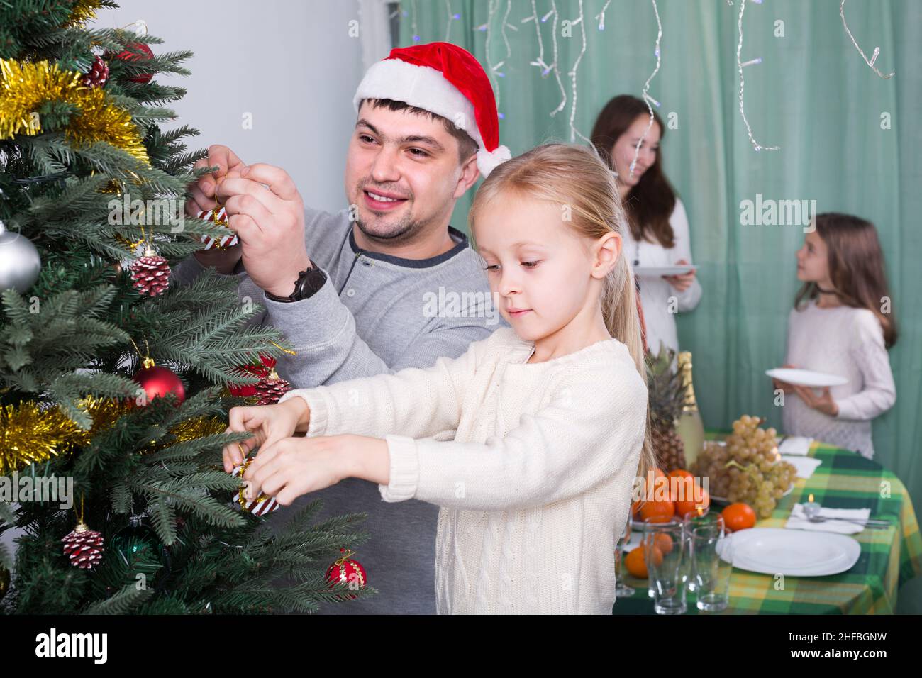 Family decorating Christmas tree at home Stock Photo - Alamy