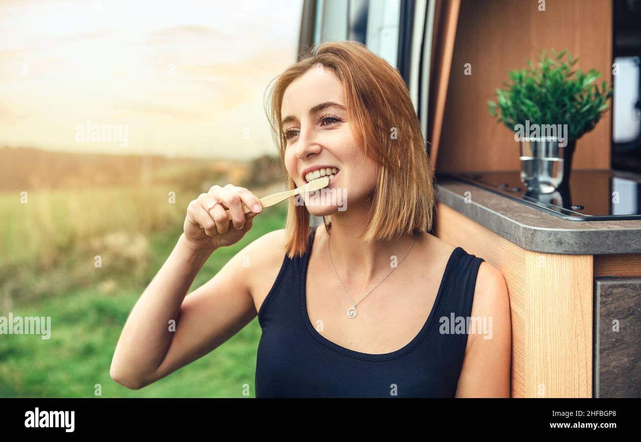 Woman brushing her teeth with a bamboo toothbrush outdoors Stock Photo ...