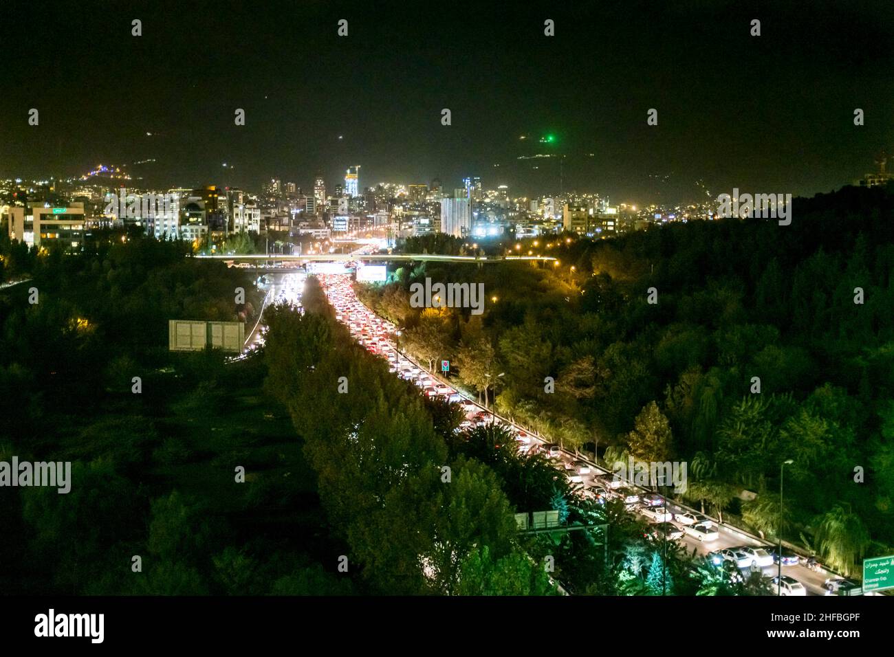 Heavy traffic at night on the Modarres Expressway, lined with parks ...