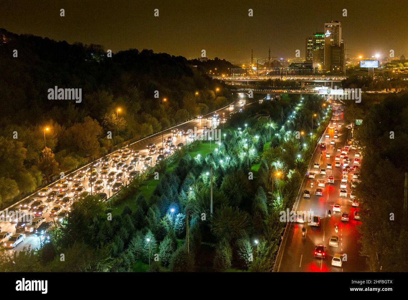 Heavy traffic at night on the Modarres Expressway, lined with parks ...