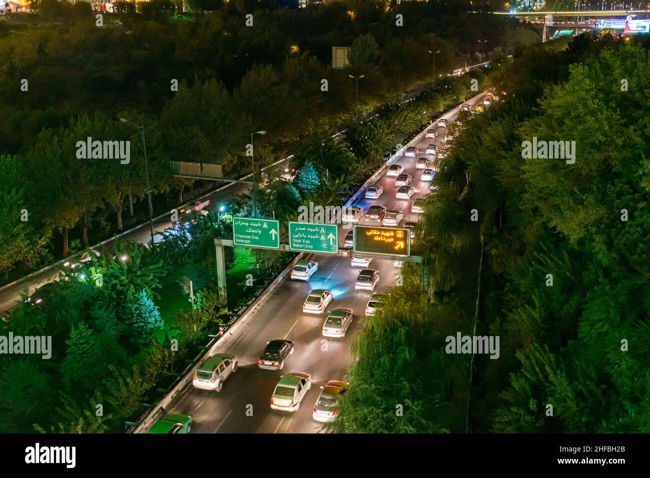 Heavy traffic at night on the Modarres Expressway, lined with parks ...