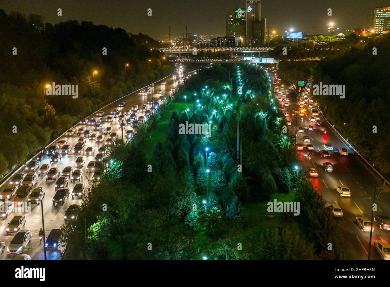 Heavy traffic at night on the Modarres Expressway, lined with parks ...
