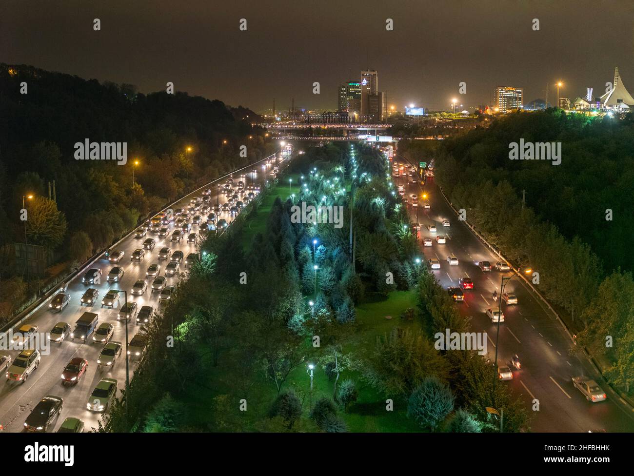 Heavy traffic at night on the Modarres Expressway, lined with parks ...
