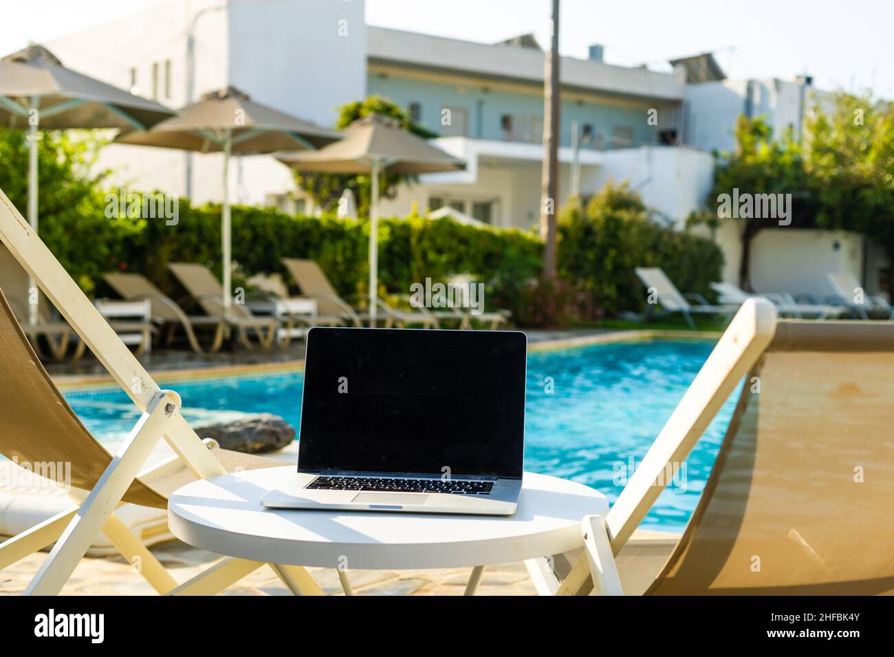 laptop computer on table pool background Stock Photo - Alamy