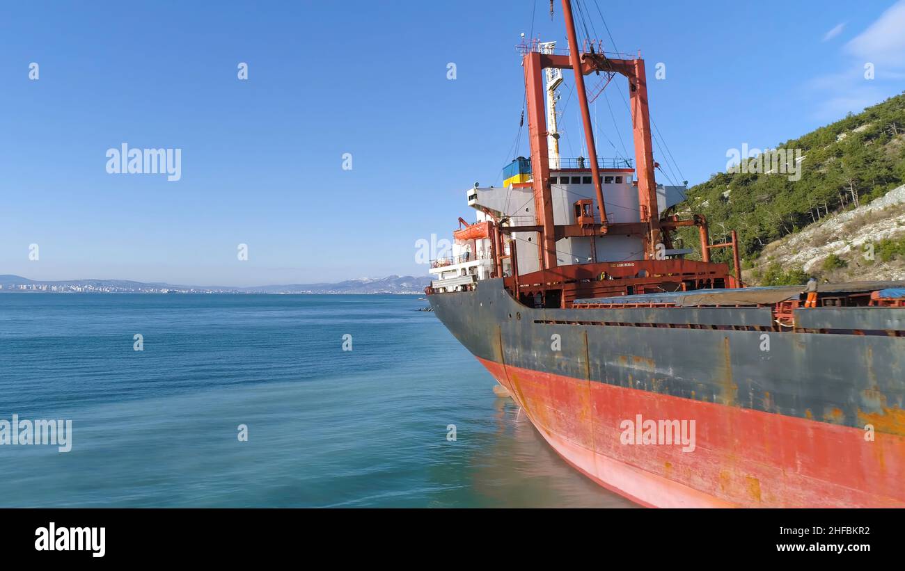 Aerial for red, empty barge moored along the sea shore near a slope ...