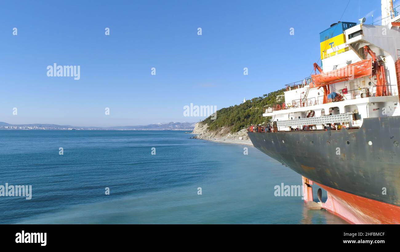 Aerial for red, empty barge moored along the sea shore near a slope ...