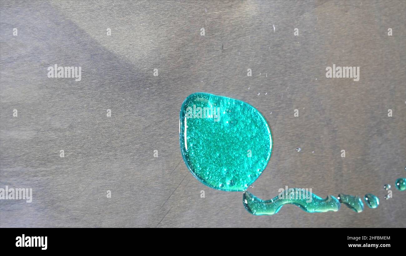 Top view of big turquoise stain on grey metal background holding stil ...