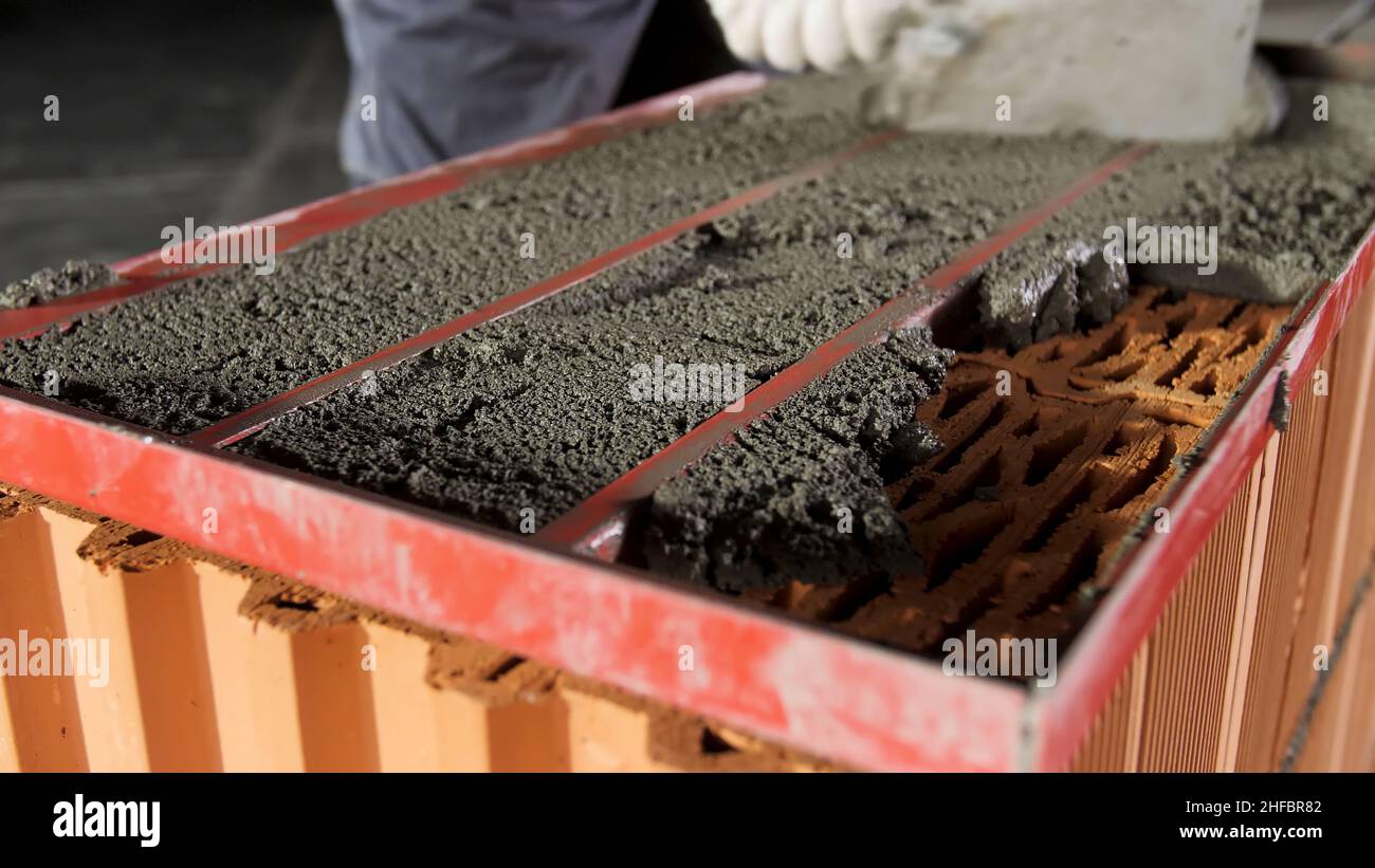 Construction worker using trowel for levelling raw mortar for the brick ...