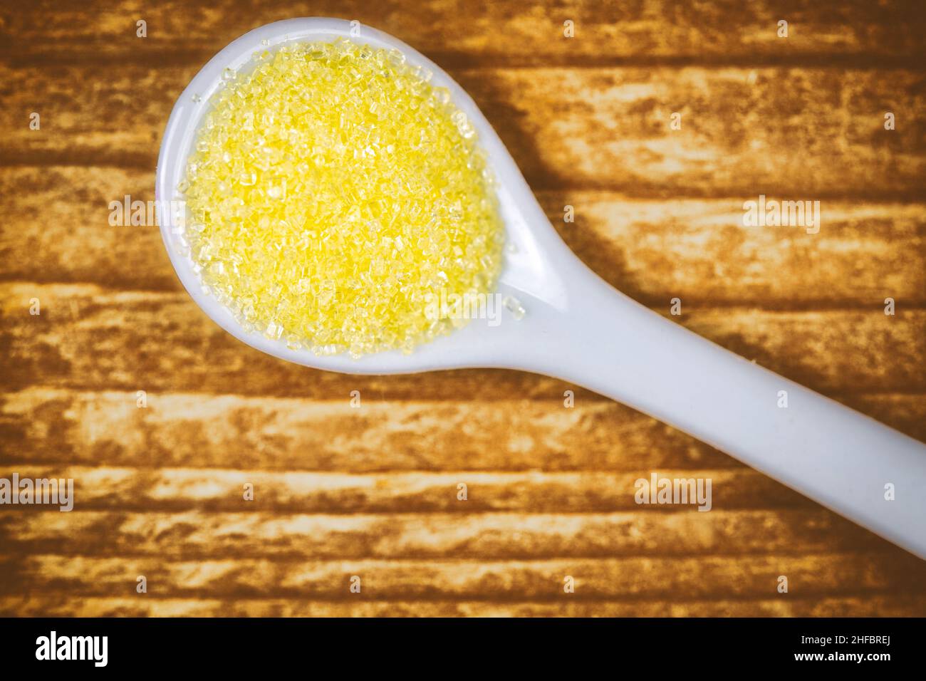 Confectionary yellow sugar in a white spoon Stock Photo - Alamy