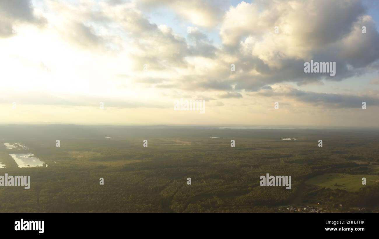 Aerial view of boundless forest under white clouds and blue sky ...