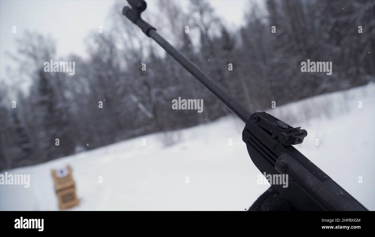 A man aiming a pellet gun towards a target, practicing his aim in the ...