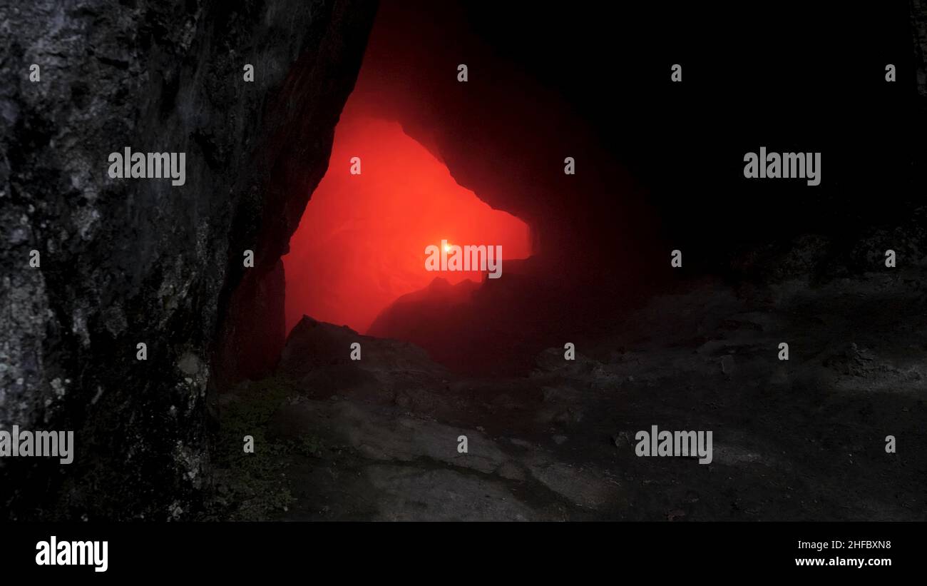 Man silhouette in an underground abandoned crypt with burning red ...
