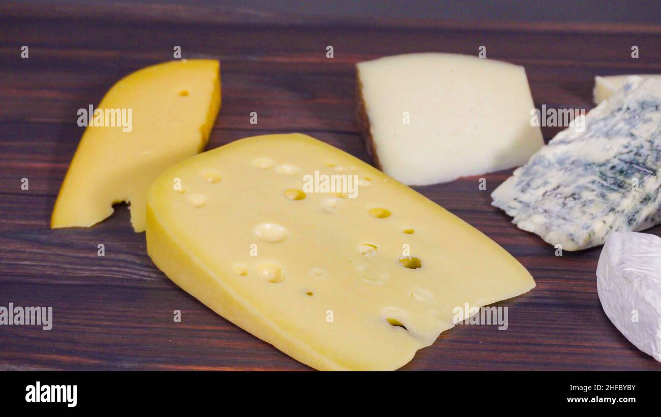 Large wedges of gourmet cheese on a rustic wood background Stock Photo ...