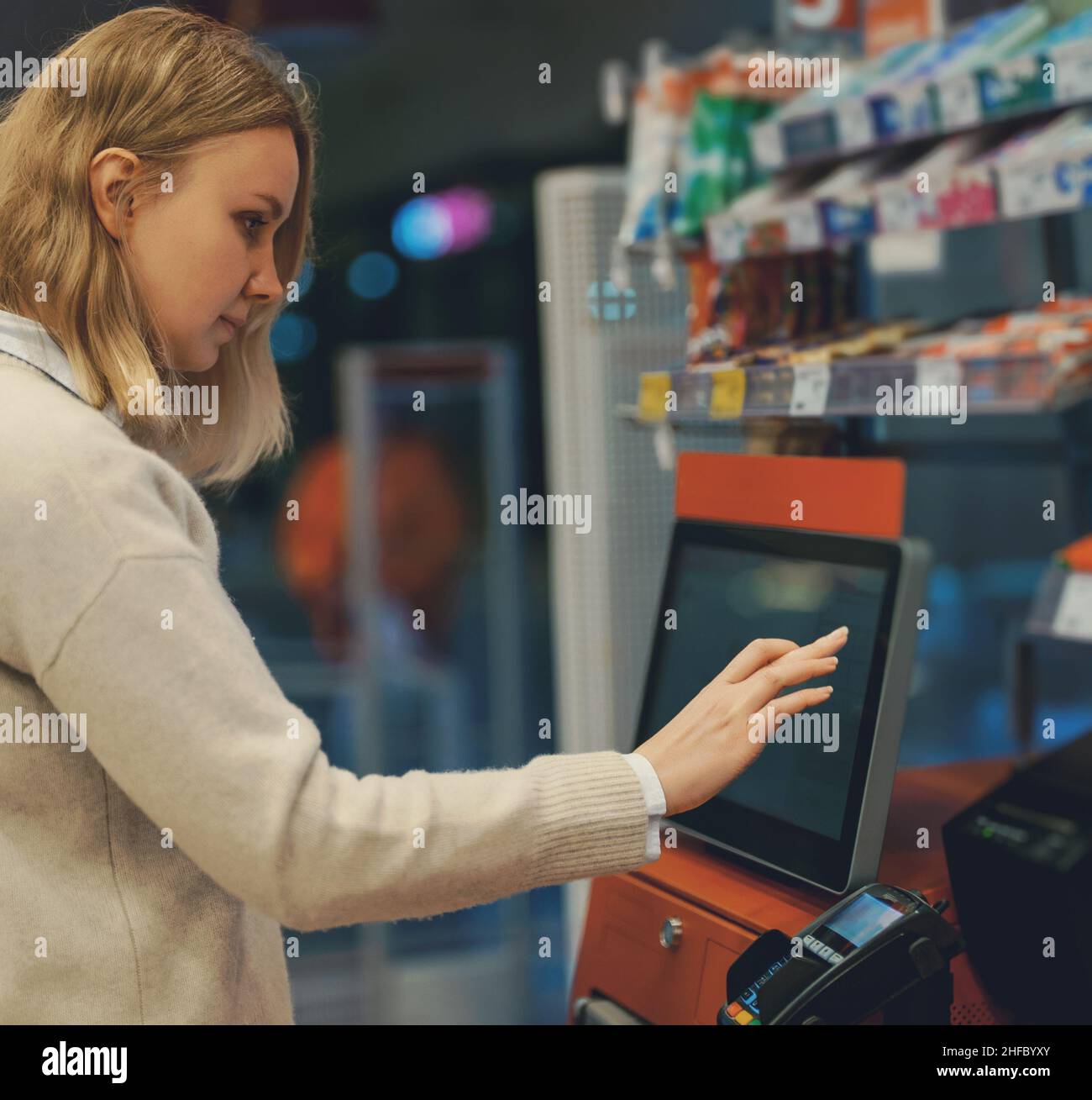 Woman pays at self-checkouts in supermarket Stock Photo - Alamy