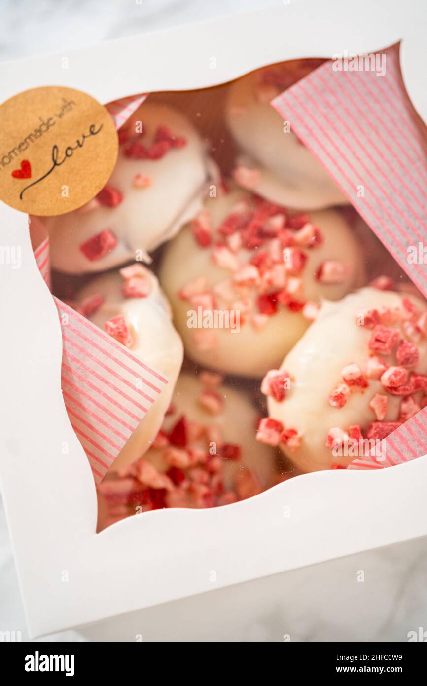 Packing freshly baked peppermint white chocolate cookies into a white ...