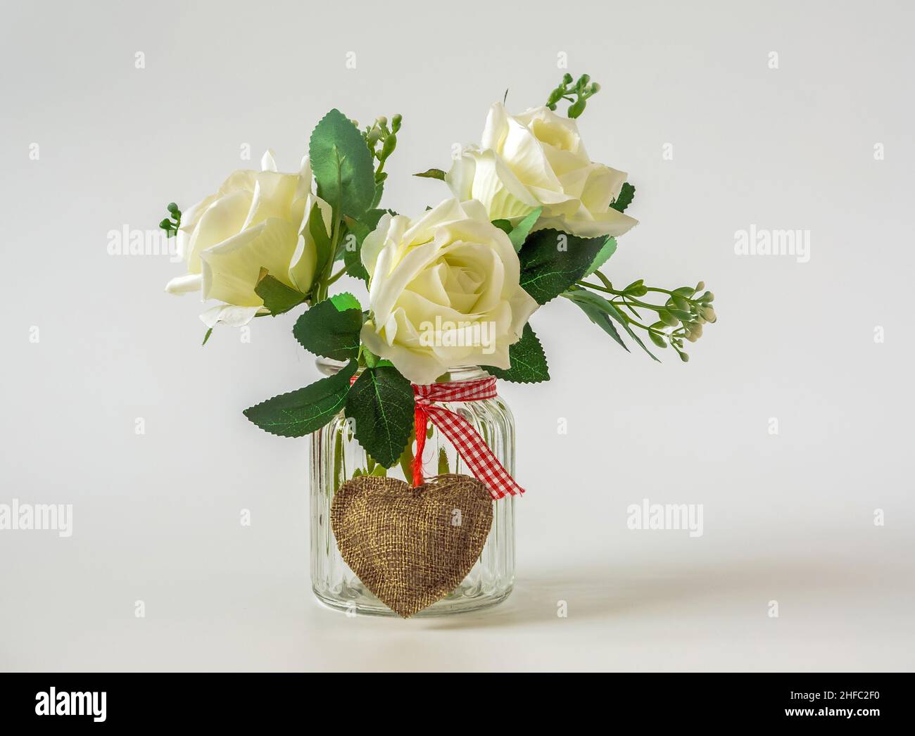 still life, floral composition on white background, roses in a jar with ...