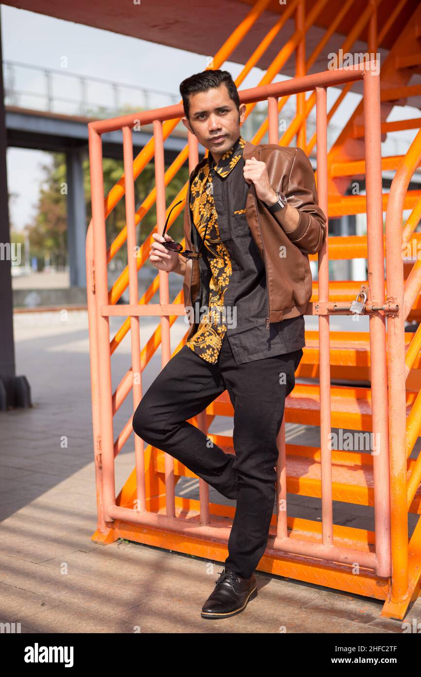 A young male model dressed in Indonesian Batik with Balinese Flower ...