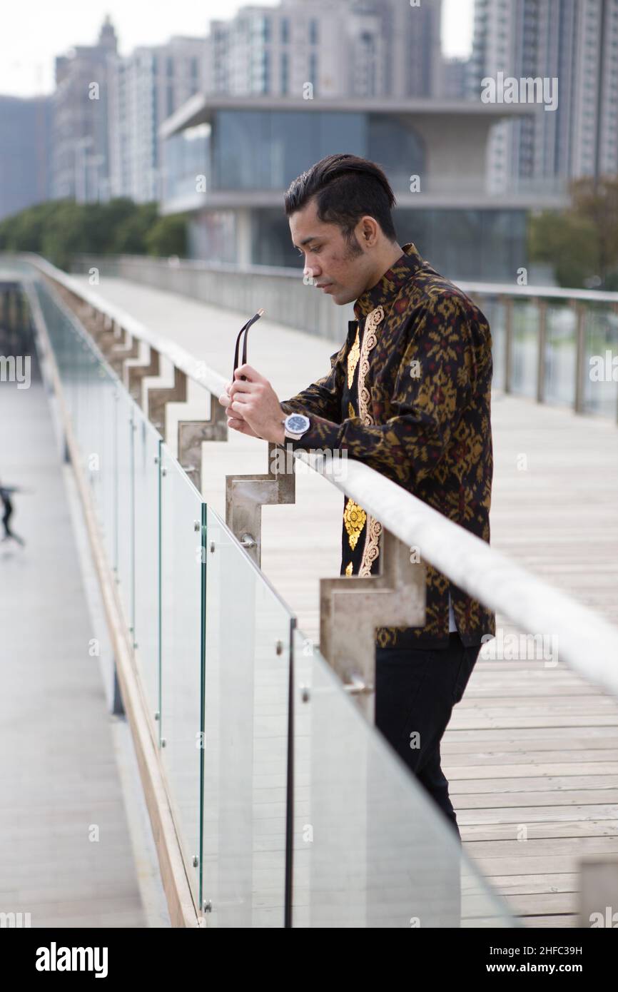 A young male model dressed in Indonesian Batik with Balinese Flower ...