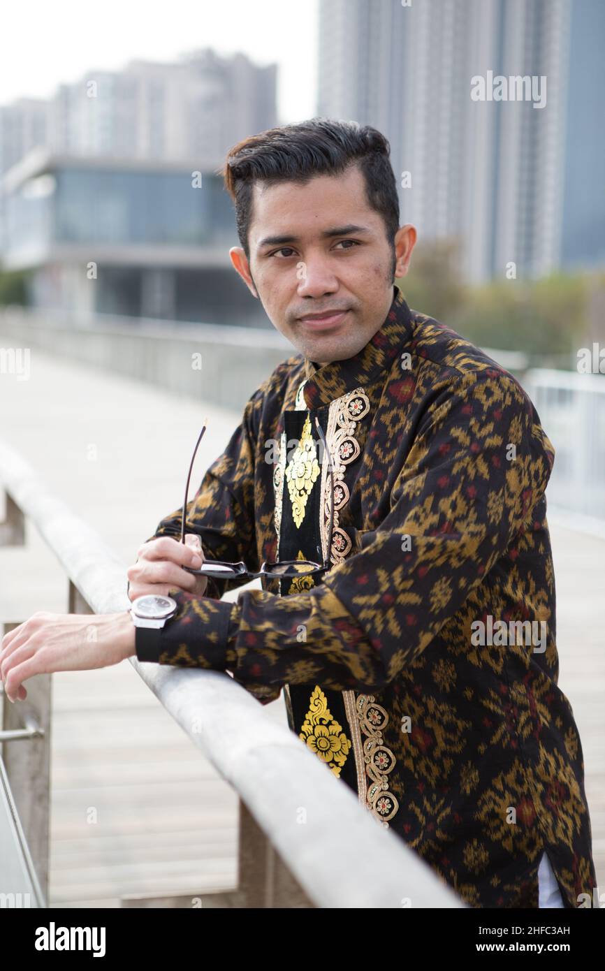 A young male model dressed in Indonesian Batik with Balinese Flower ...