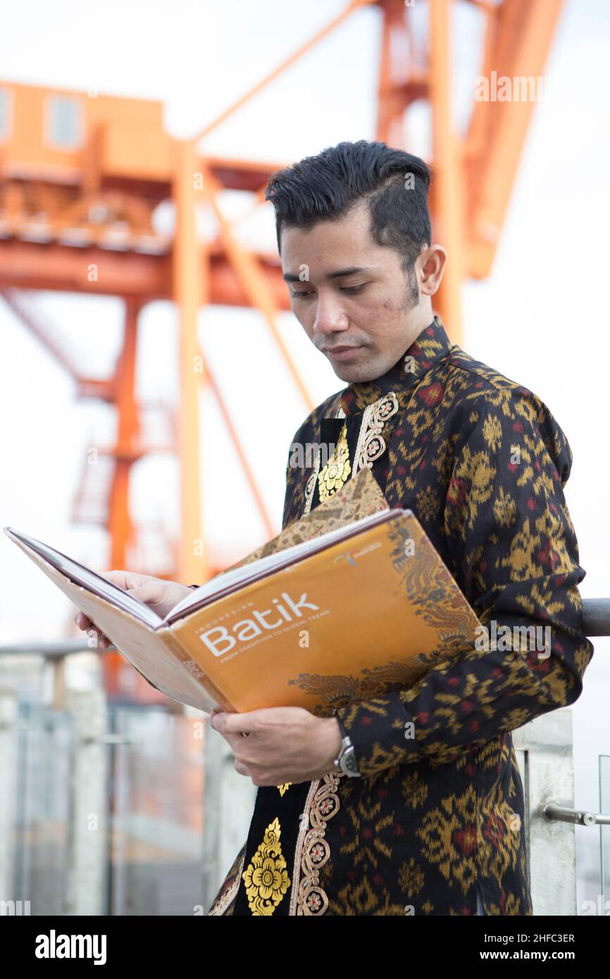 A young male model dressed in Indonesian Batik with Balinese Flower ...