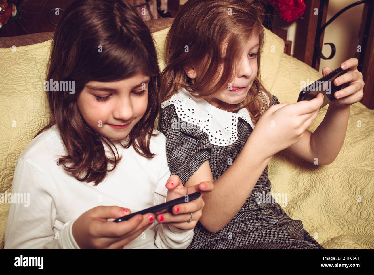Little girls playing games on their mobile phones Stock Photo - Alamy