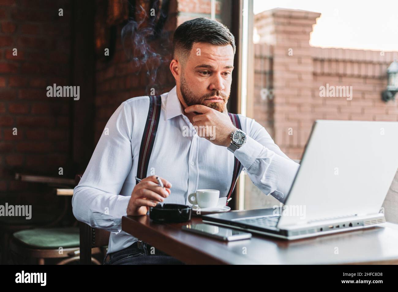 Young businessman working in a cafe, smoking Stock Photo - Alamy