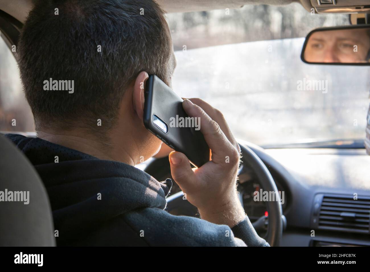 Driver with a phone behind the wheel Stock Photo - Alamy