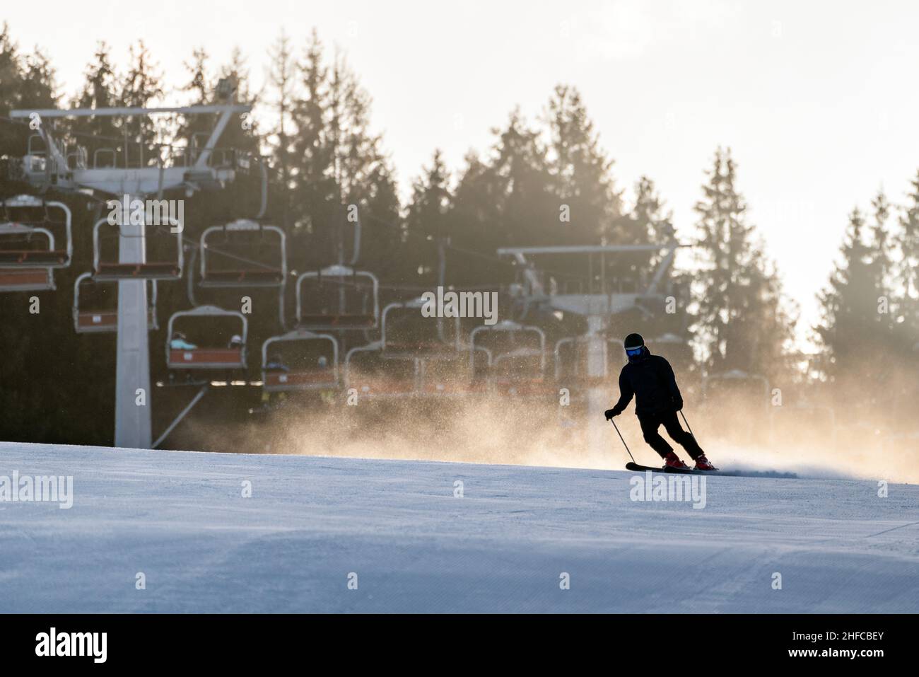 Skier skiing downhill in on slope mountain resort and ski-lift at ...