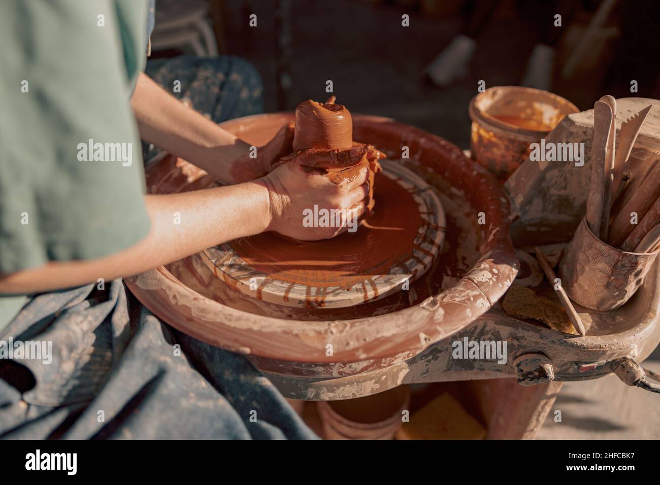 Clay artist modeling product on potter wheel in workshop Stock Photo ...