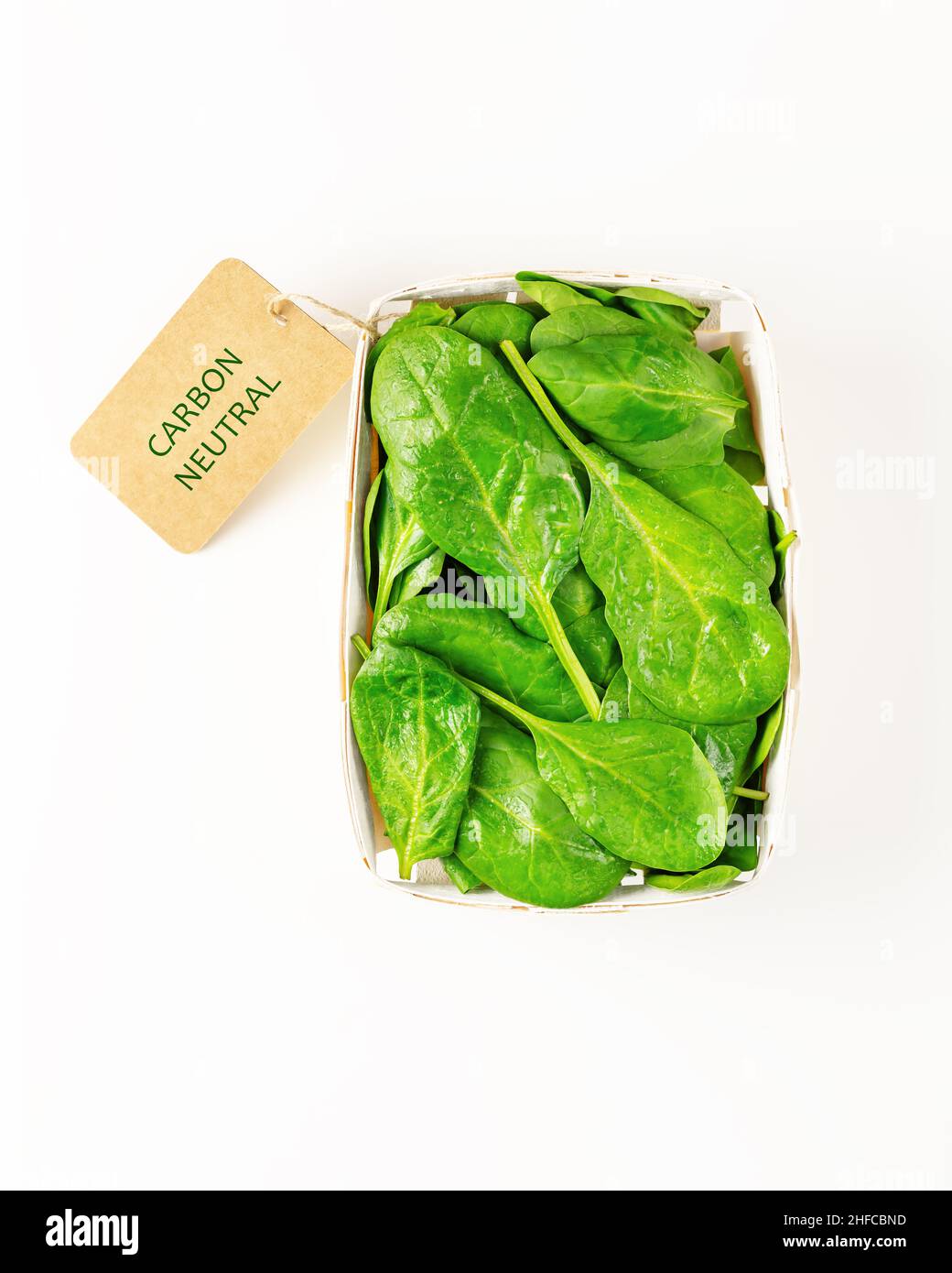 Isolated young organic spinach in an eco friendly tree bark package ...
