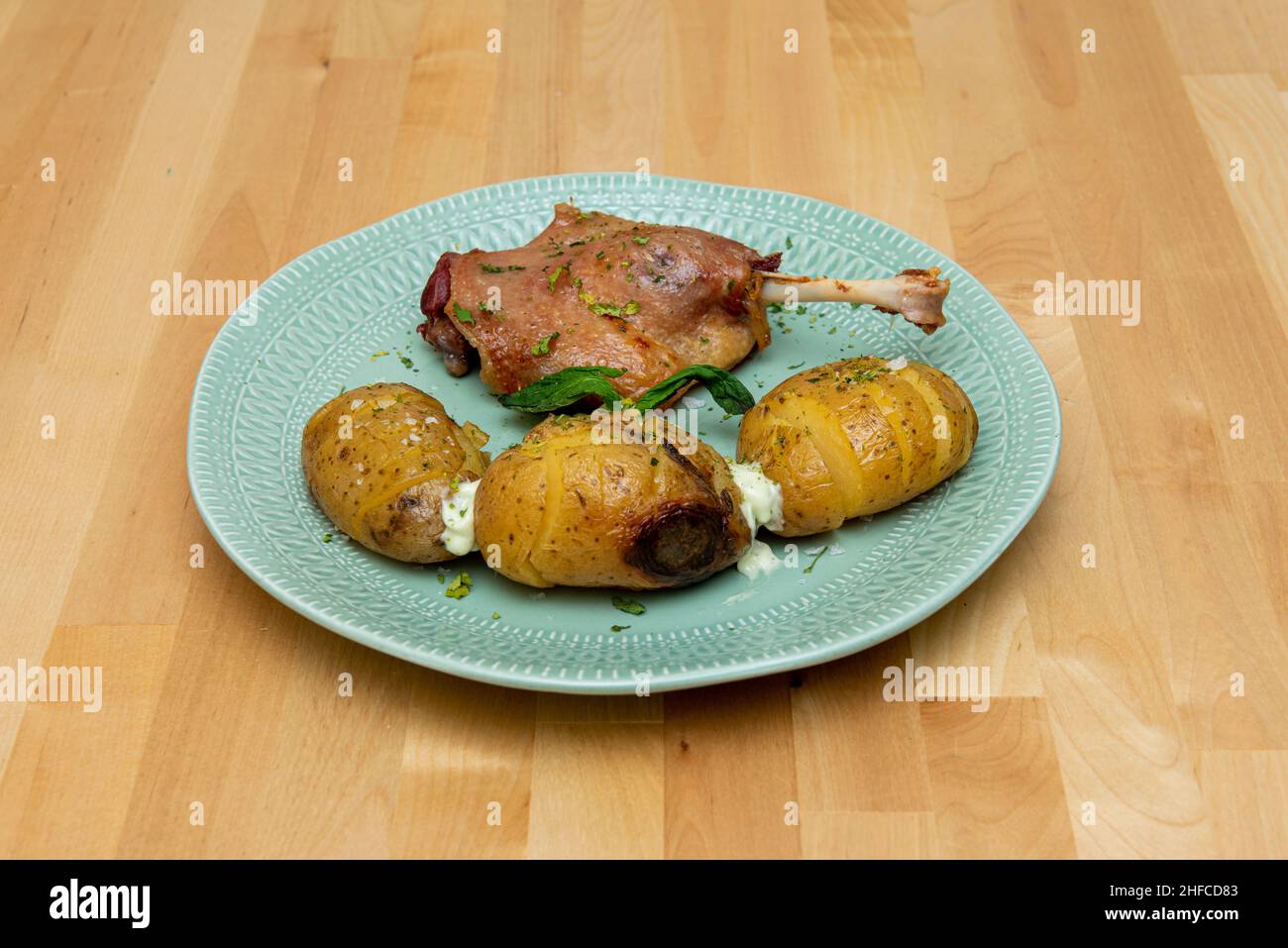 Duck leg cooked in the oven with potato garnish and garlic sauce Stock ...