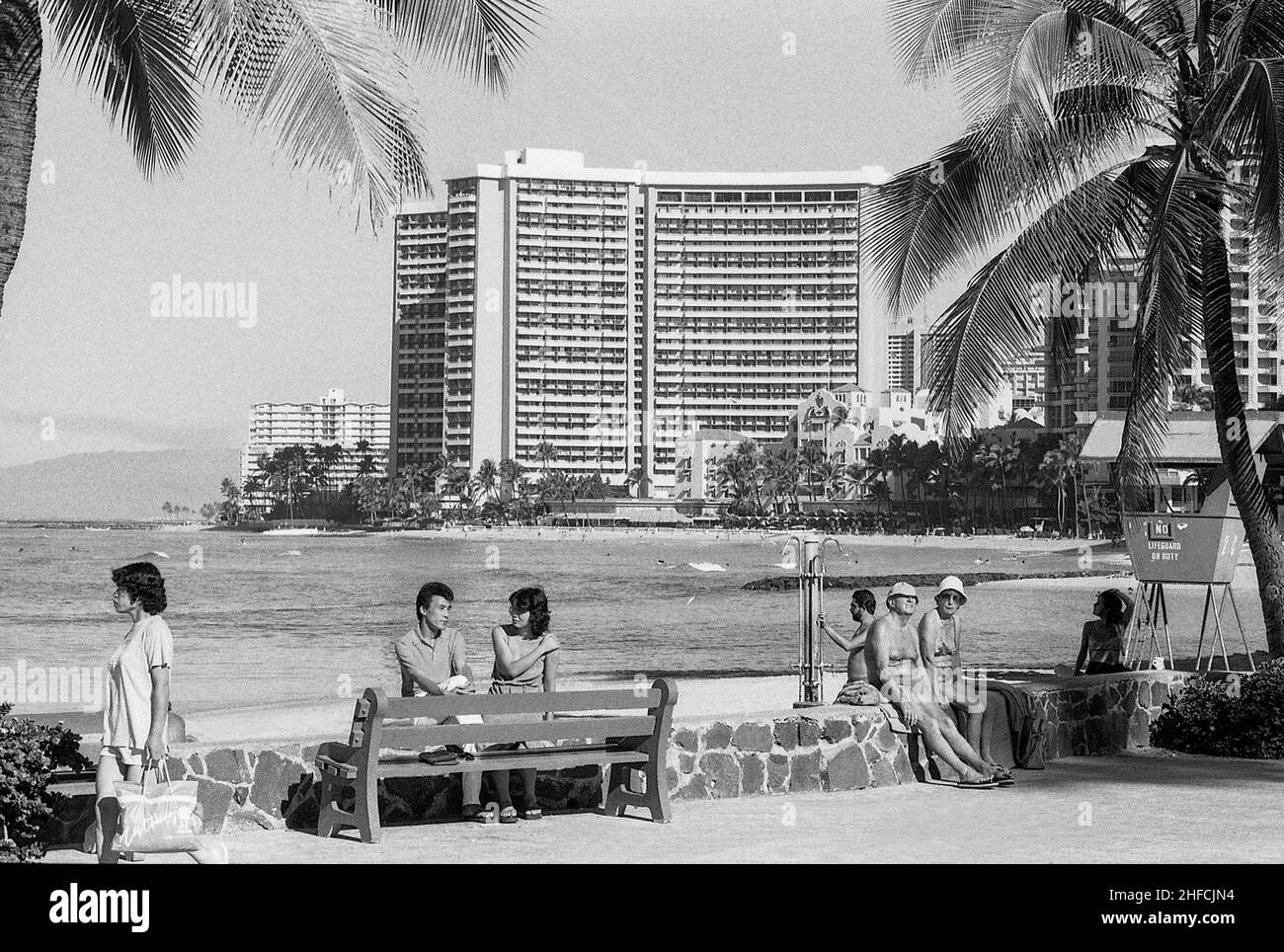 HAWAII HONOLULU Sunbathing people on the beach below luxury hotels ...