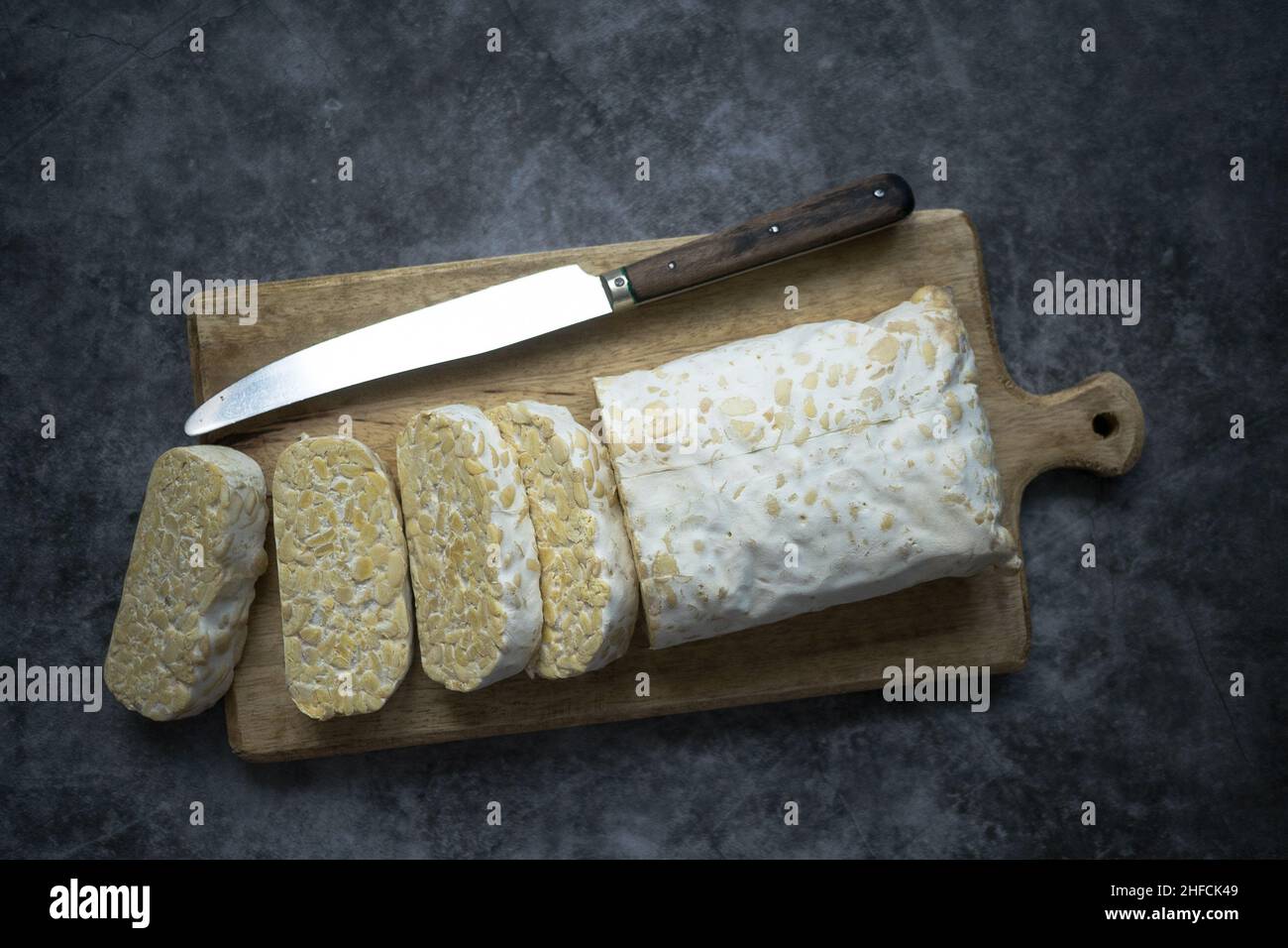 Sliced fresh raw tempeh on cutting board, Tempeh is very famous ...