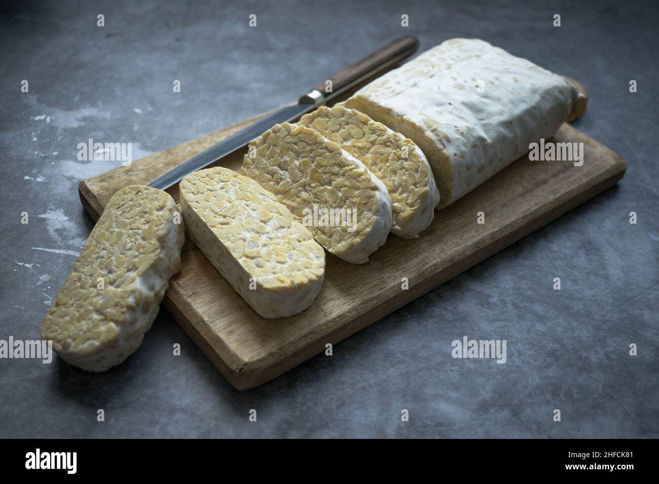 Sliced fresh raw tempeh on cutting board, Tempeh is very famous ...