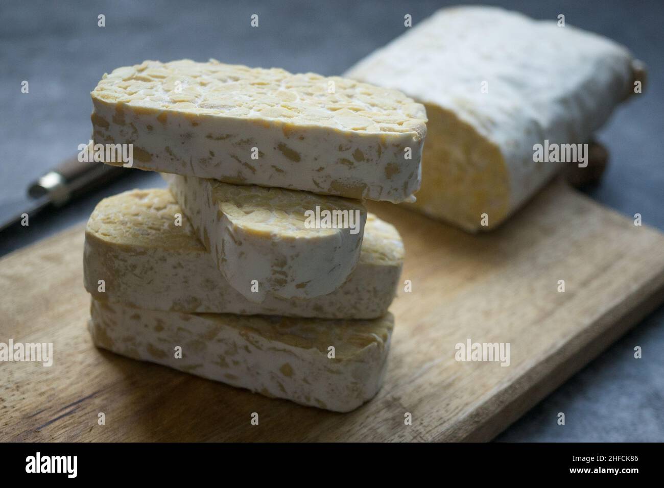 Sliced fresh raw tempeh on cutting board, Tempeh is very famous ...