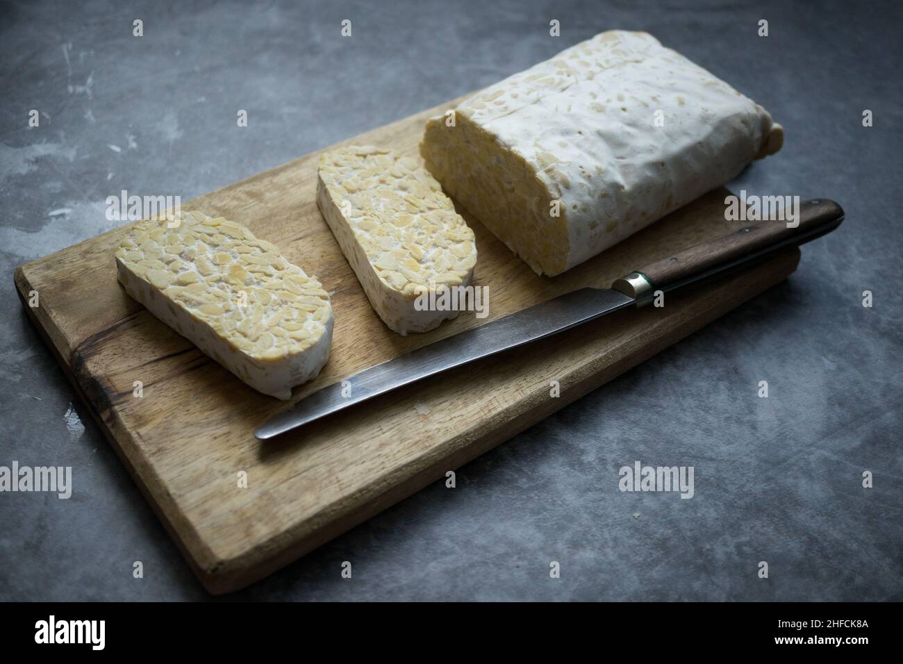 Sliced fresh raw tempeh on cutting board, Tempeh is very famous ...