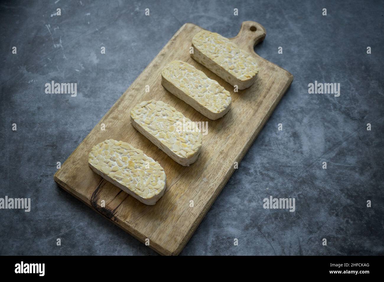 Sliced fresh raw tempeh on cutting board, Tempeh is very famous ...