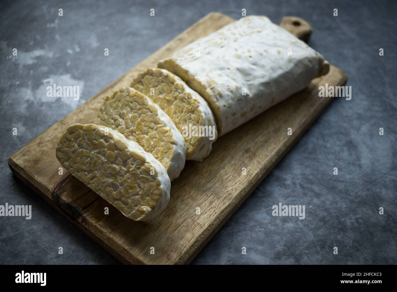 Sliced fresh raw tempeh on cutting board, Tempeh is very famous ... Sliced fresh raw tempeh on cutting board, Tempeh is very famous ...
