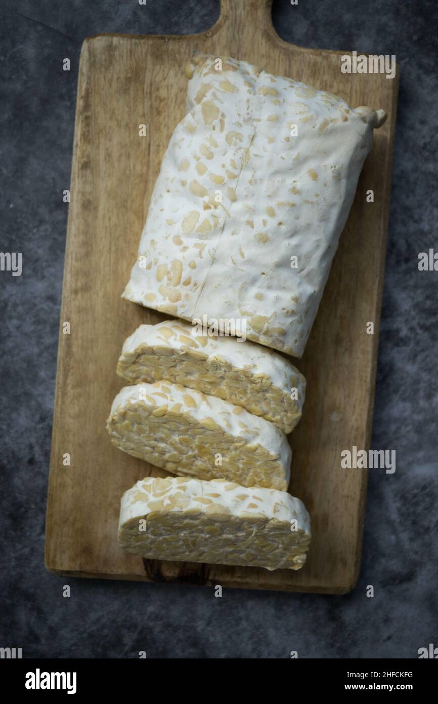 Sliced fresh raw tempeh on cutting board, Tempeh is very famous ... Sliced fresh raw tempeh on cutting board, Tempeh is very famous ...
