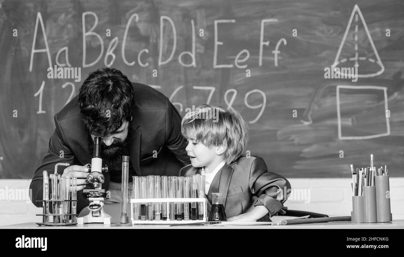 teacher man with little boy. school kid scientist studying science ...