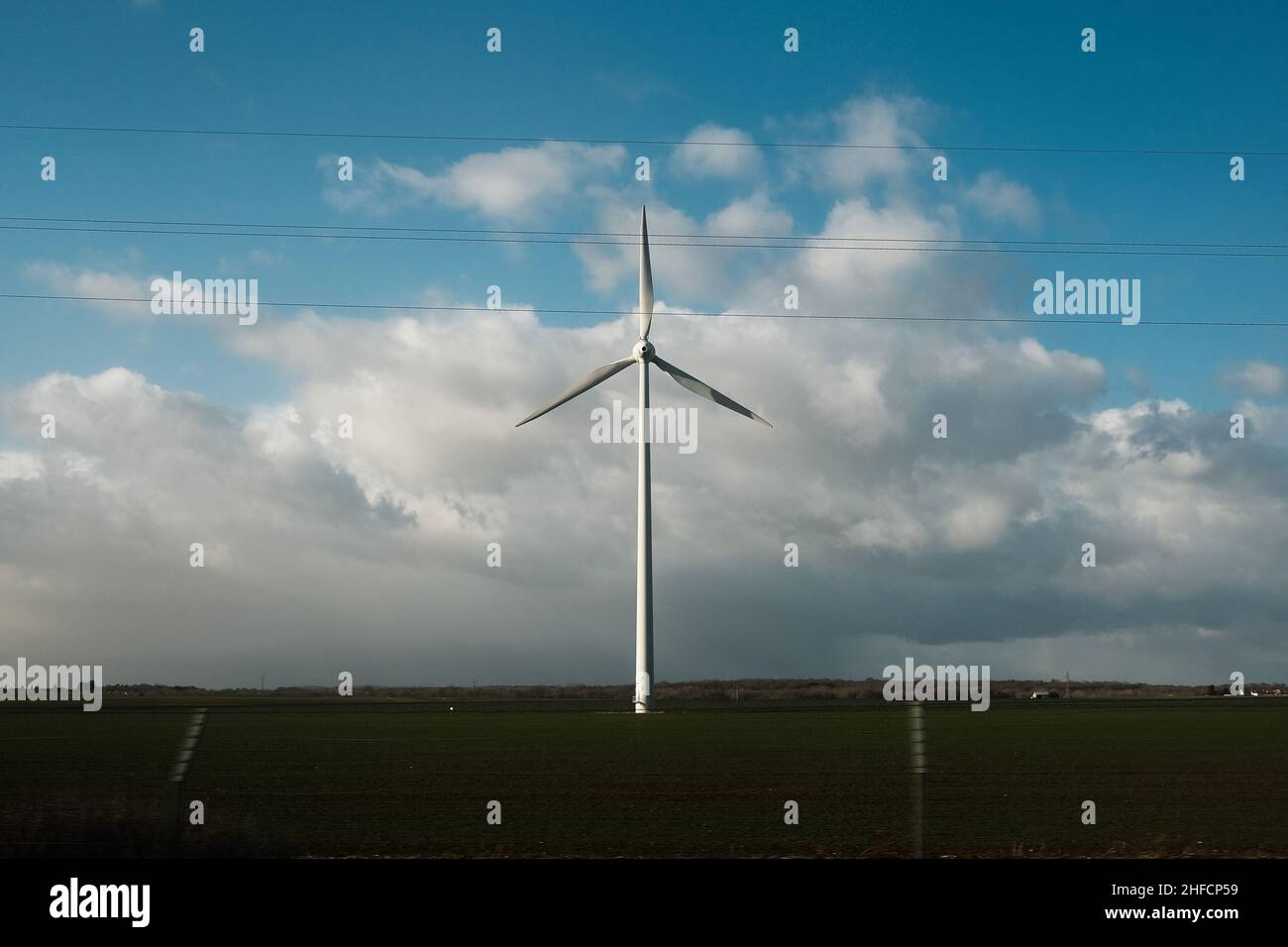 This photo shows wind turbines, standing in the middle of farmland ...