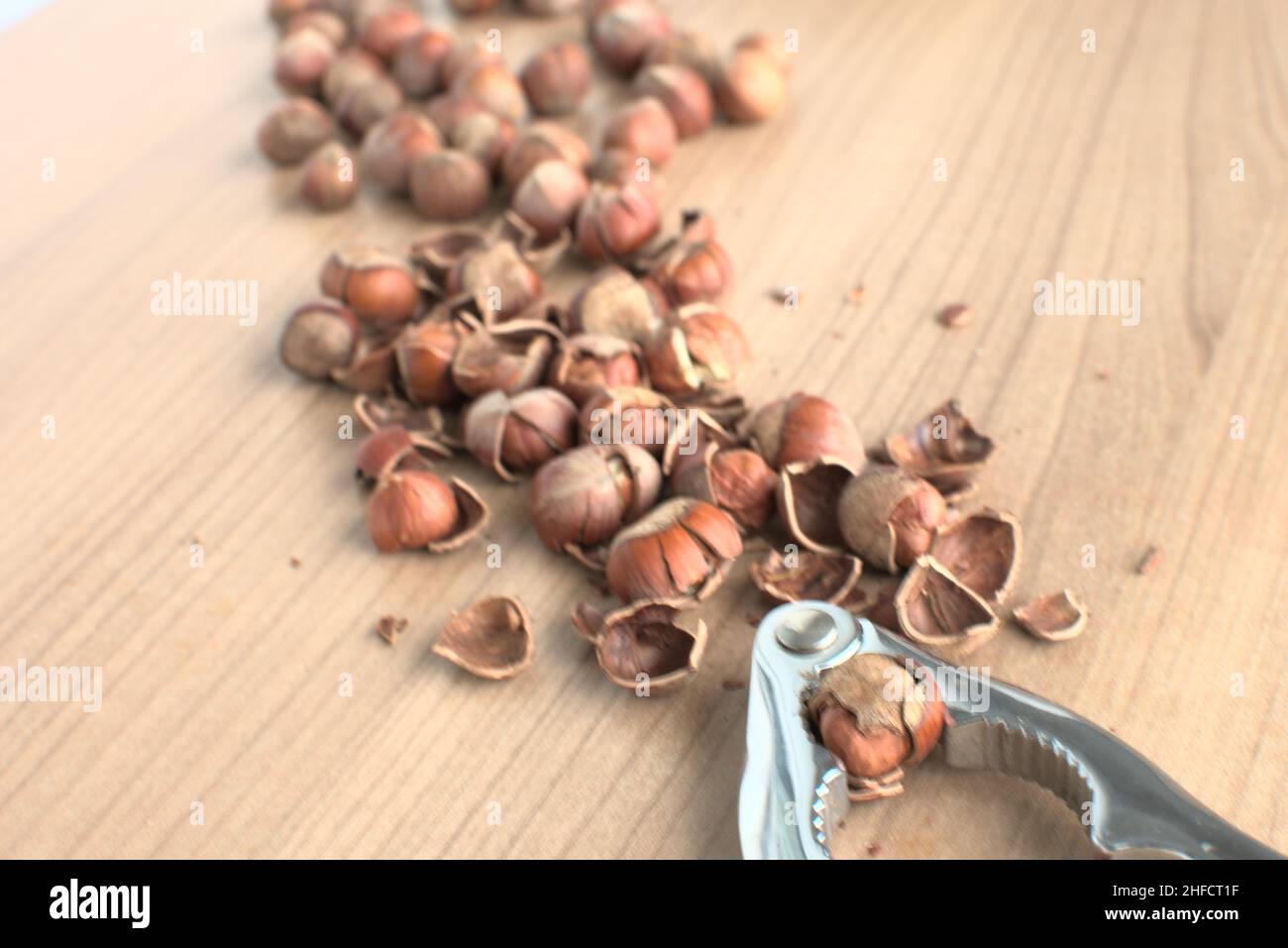 Broken hazelnuts with nutcracker on a table. Ready to eat nuts Stock ...
