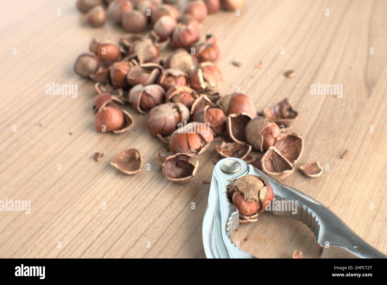 Broken hazelnuts with nutcracker on a table. Ready to eat nuts Stock ...