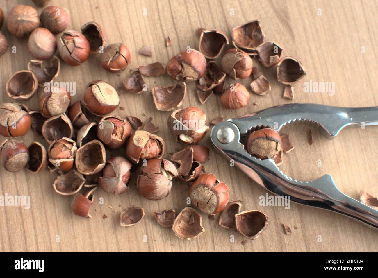 Broken hazelnuts with nutcracker on a table. Ready to eat nuts Stock ...