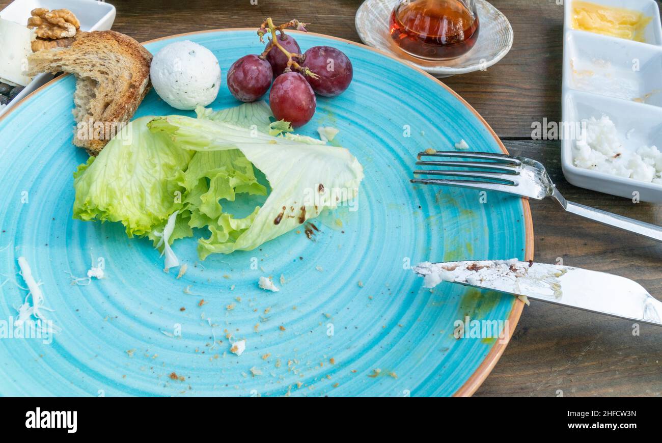 leftovers, closeup empty and dirty plate on the breakfast table ...