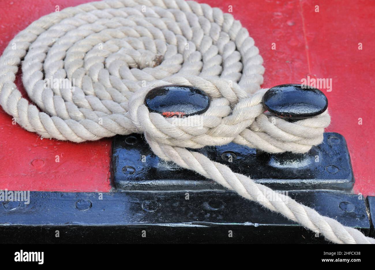 Ship bollard with rope around it Stock Photo - Alamy