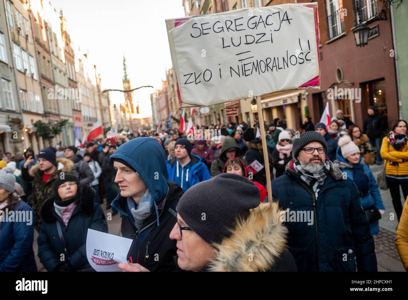 A protester holds a placard saying "Segregation of people = evil and ...