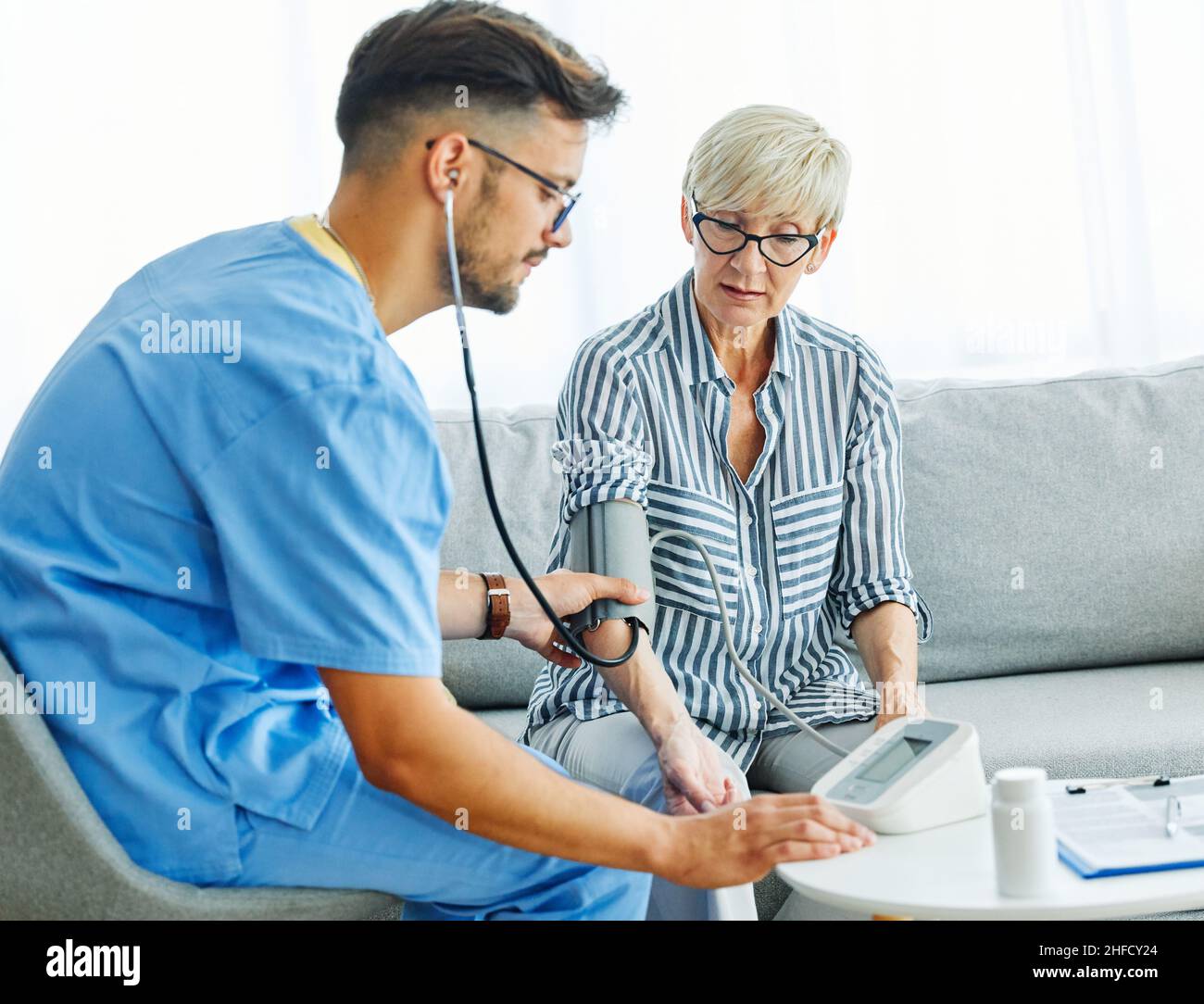 Young nurse listening elderly woman hi-res stock photography and images ...
