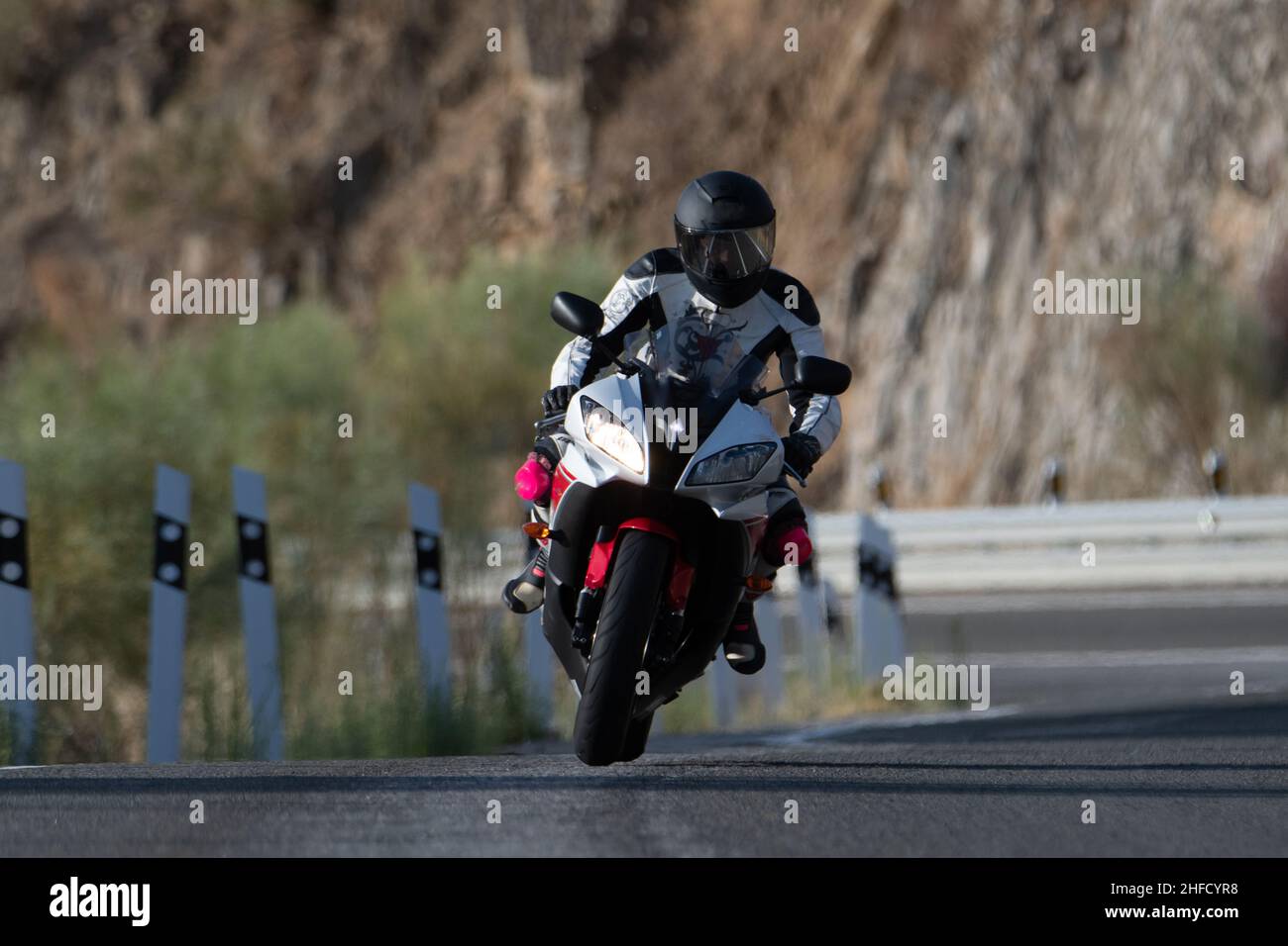 biker person with safety helmet and protective suit driving on the ...